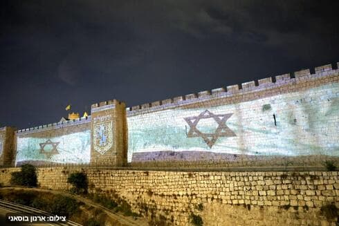 לאורך כל המלחמה: דגל ישראל יוקרן על חומות העיר העתיקה וגשר המיתרים